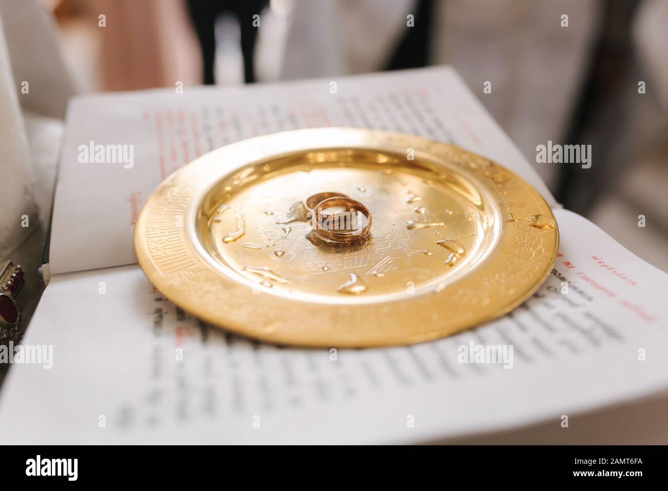 Wedding rings on golden plate in church Stock Photo - Alamy