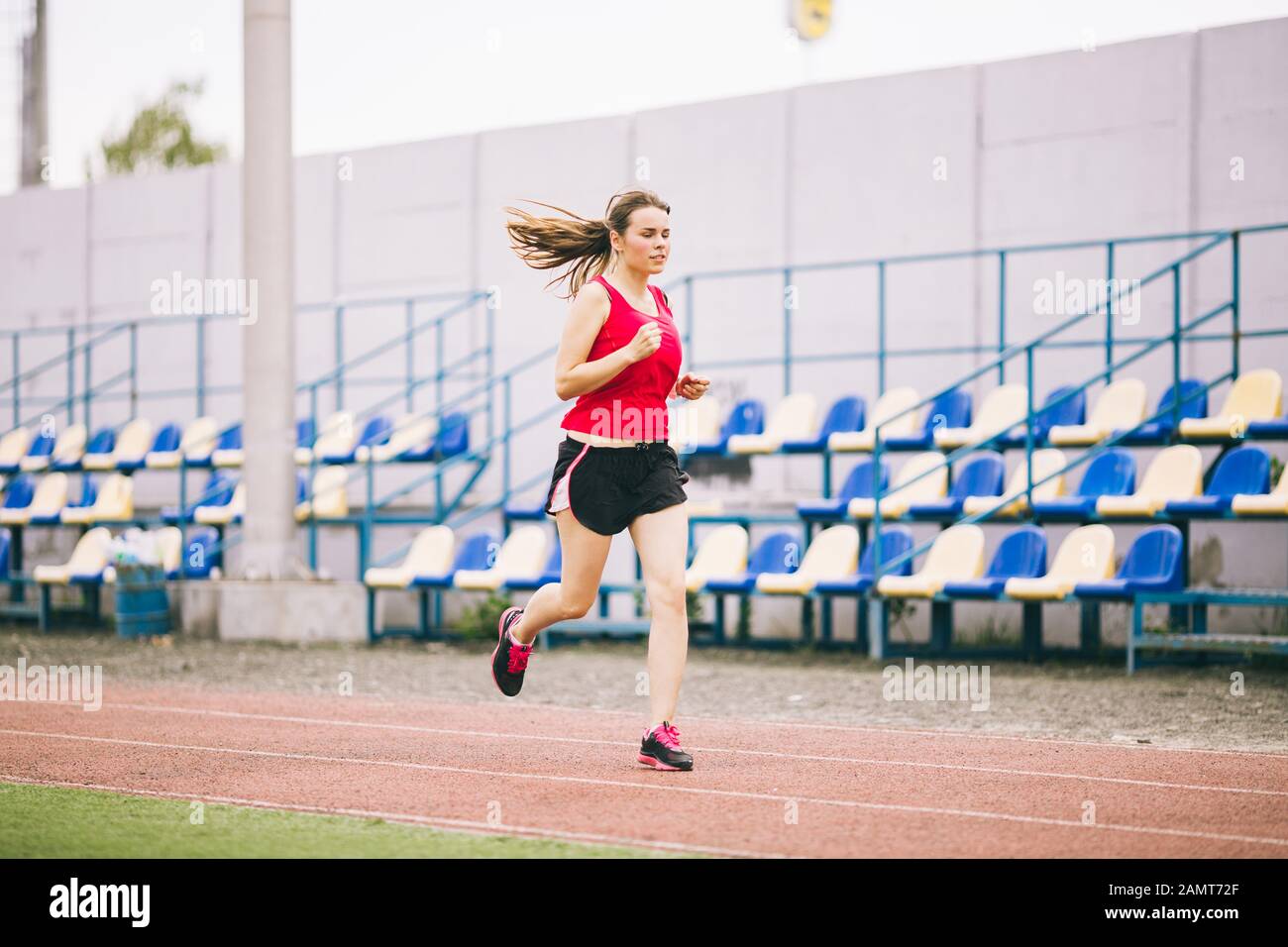 Woman Running At Stadium. Young woman running during on stadium track ...