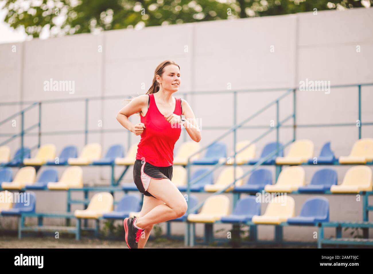 Woman Running At Stadium. Young woman running during on stadium track ...