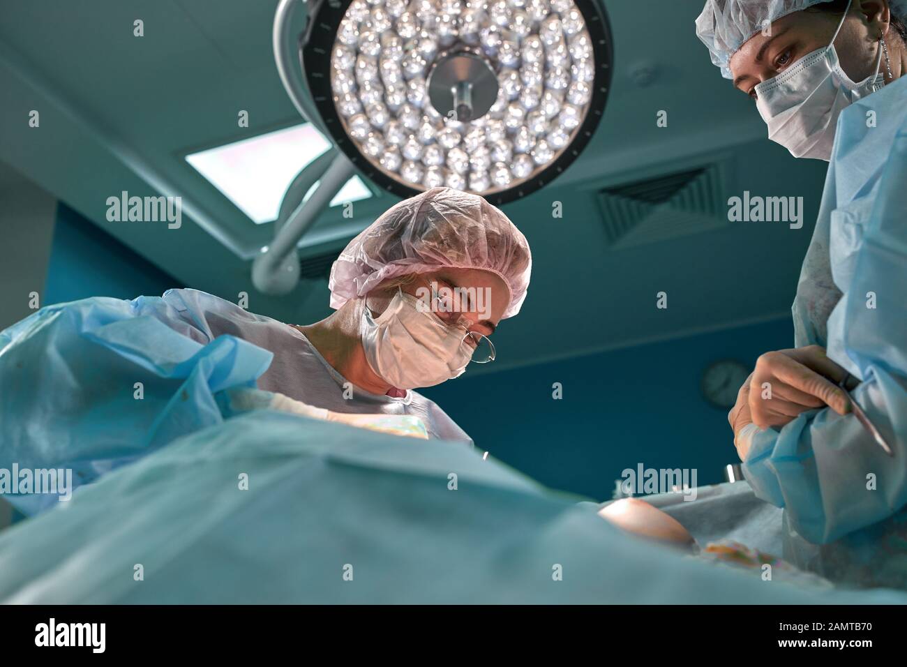 Group of surgeons in operating theater. Medical team performing surgery ...