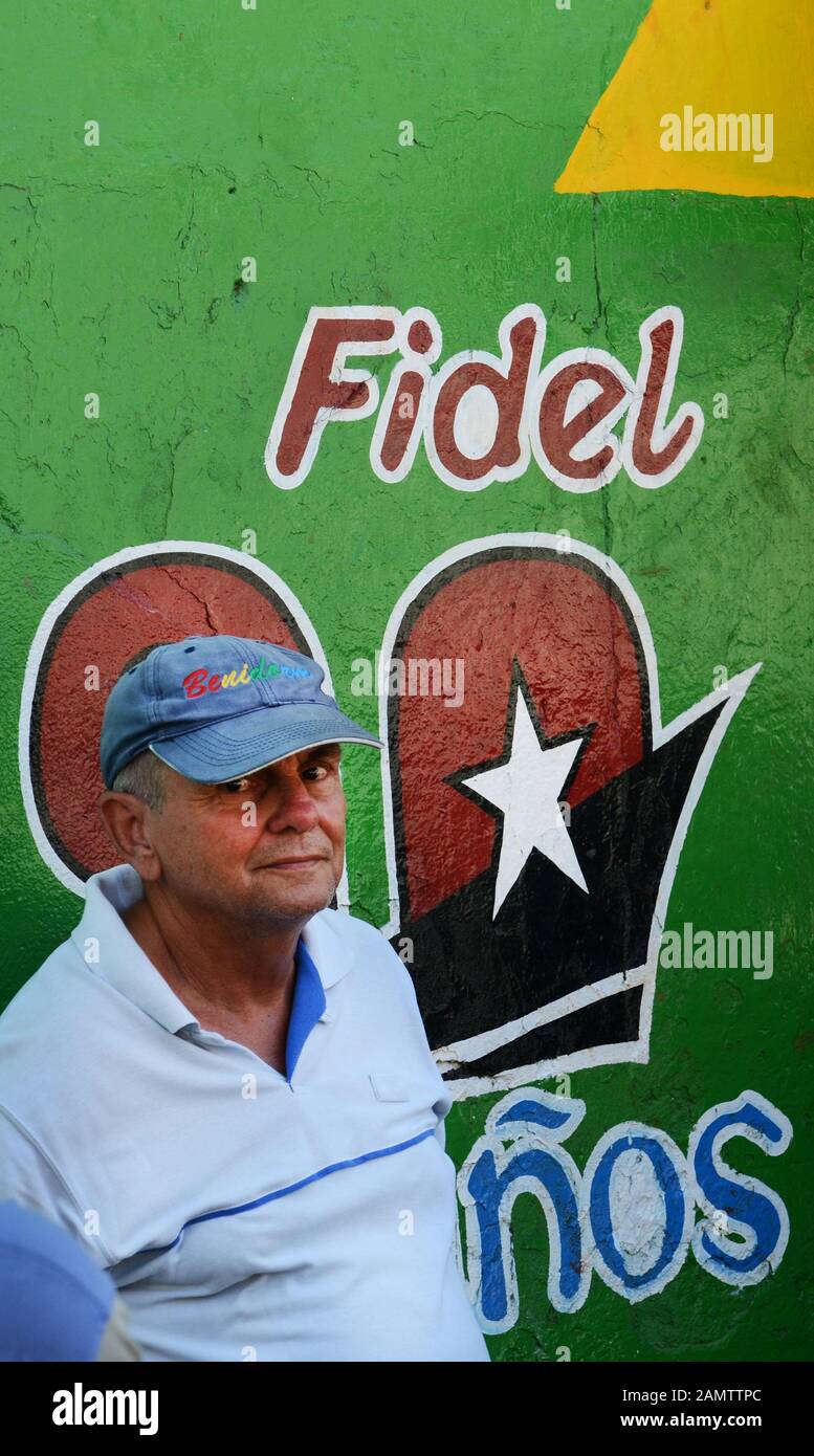 A Cuban man standing next to a colorful wall in Havana, Cuba Stock ...