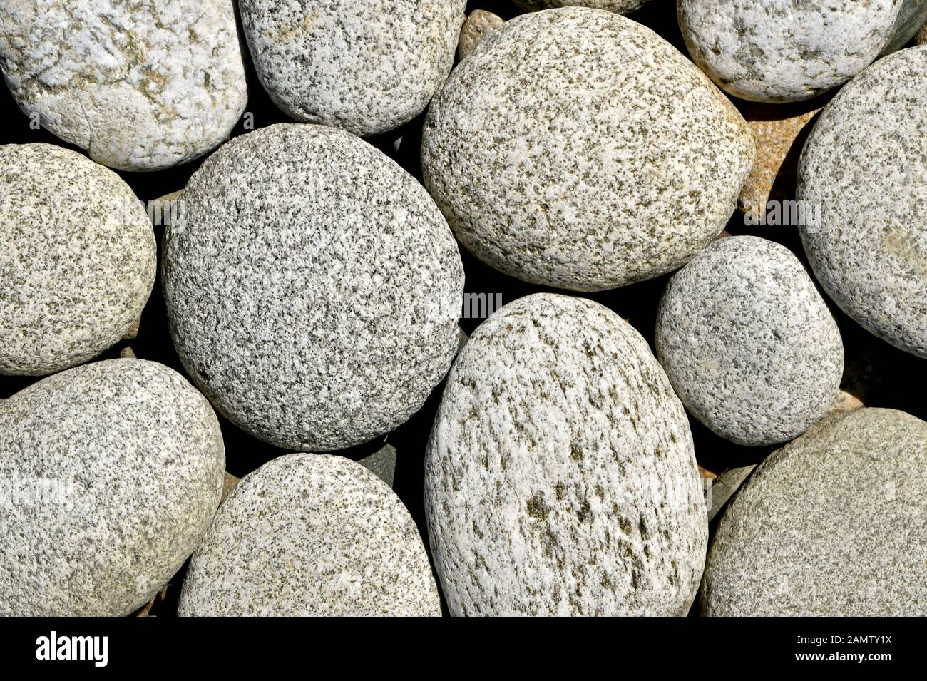 Round large stones pressed close to each other lie on the ground Stock ...