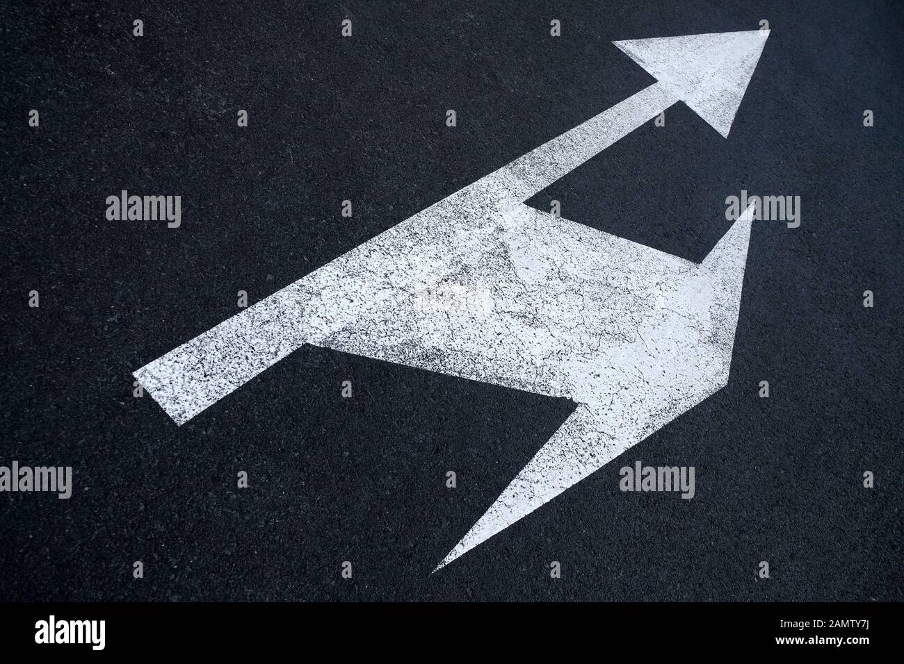 Split arrows directions icon painted on black pavement Stock Photo - Alamy