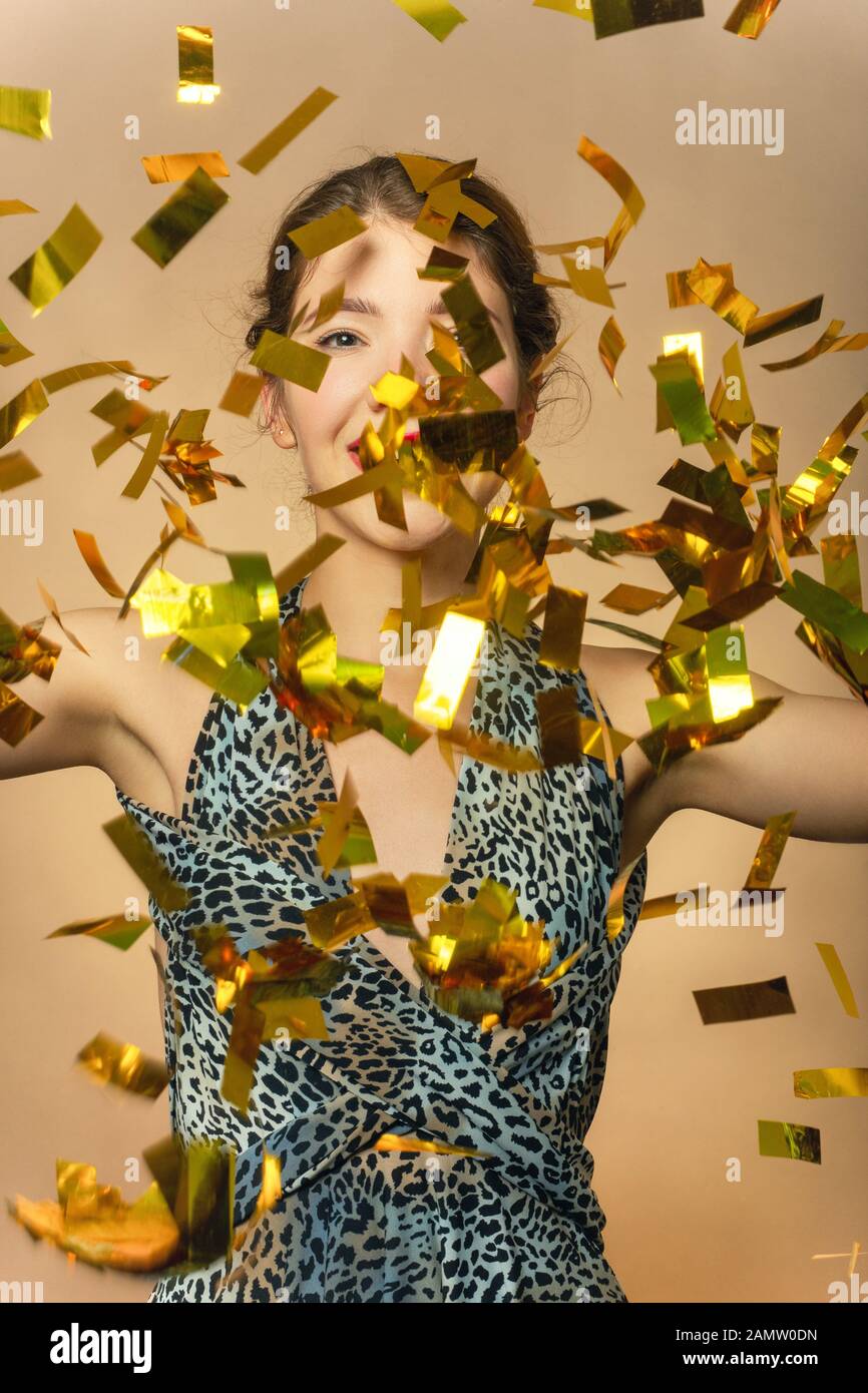 Happy girl on yellow background, golden confetti slowly scatter and ...