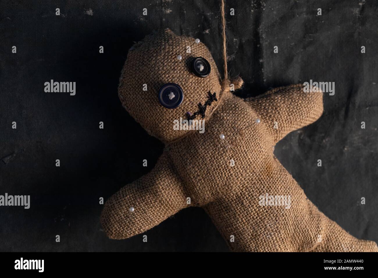 Voodoo doll on a black background with dramatic lighting. The concept ...