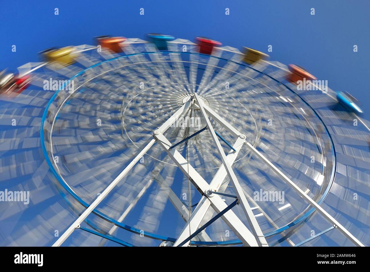 A ferris wheel with colorful cabins at a local fun fair Stock Photo - Alamy