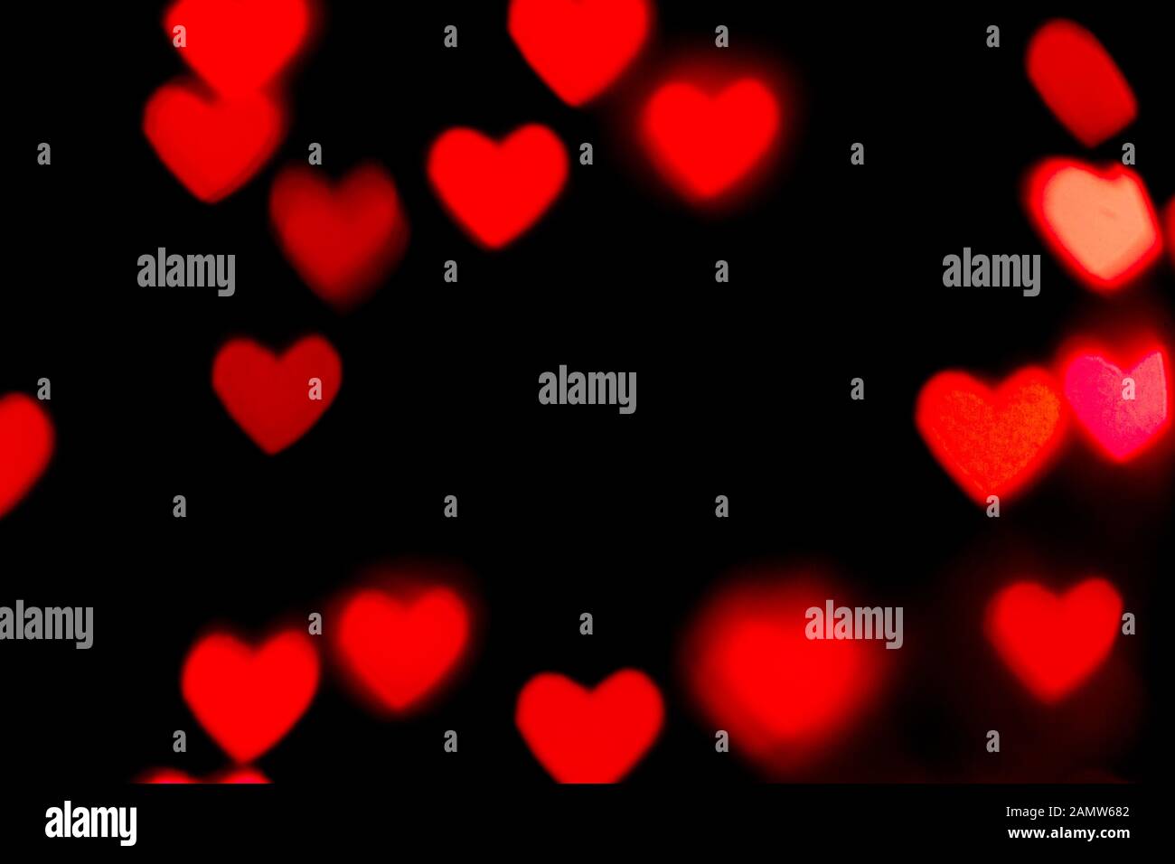 Black background with bright red warm heart shaped bokeh lights ...