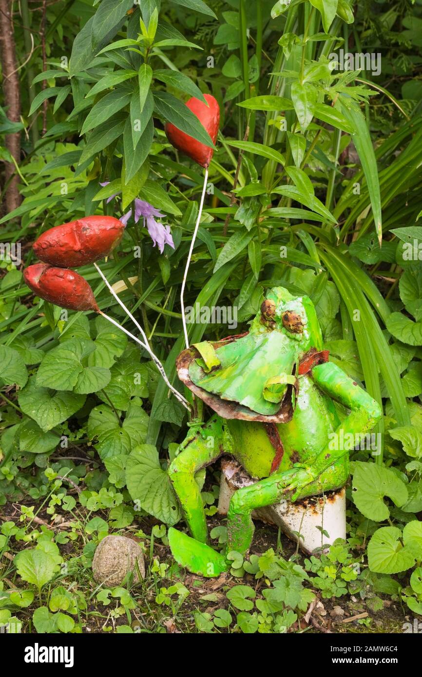 Close-up of green metal frog with red heart shaped Saint-Valentine's ...