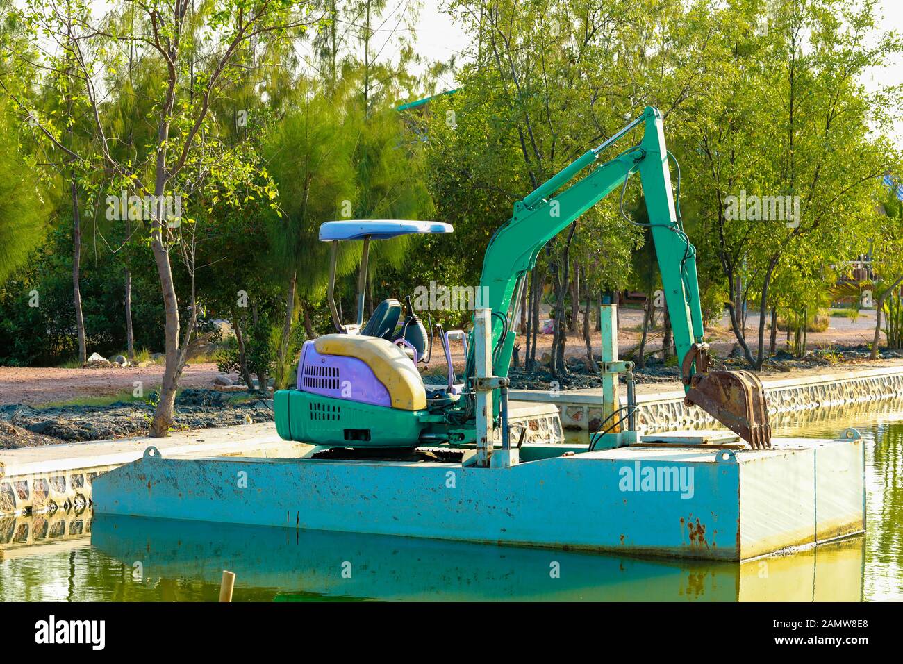 Backhoe excavator on pontoon in the pond Stock Photo - Alamy