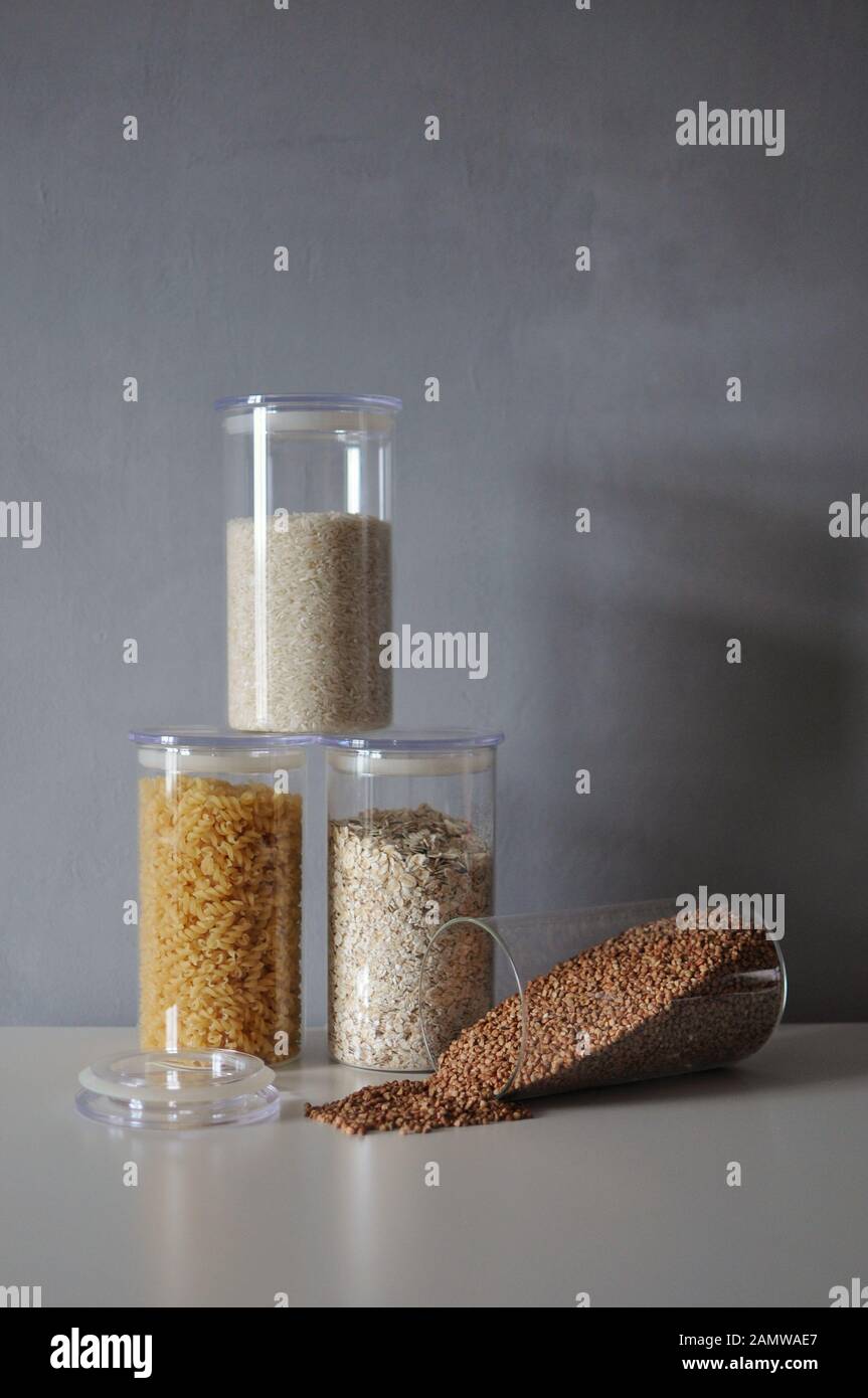 Various uncooked cereals for healthy cooking in a glass jars on grey ...