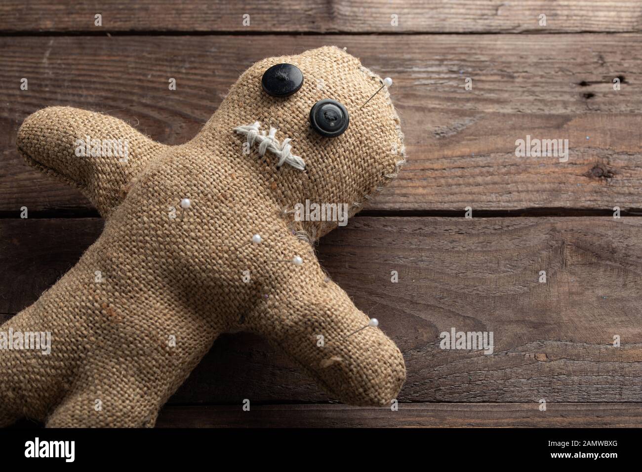 Voodoo doll on a wooden background with dramatic lighting. The concept ...