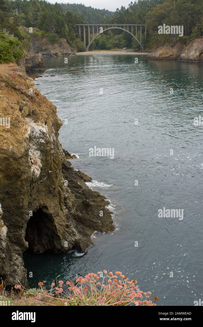 landscape of a sea cave with bridge behind Stock Photo - Alamy