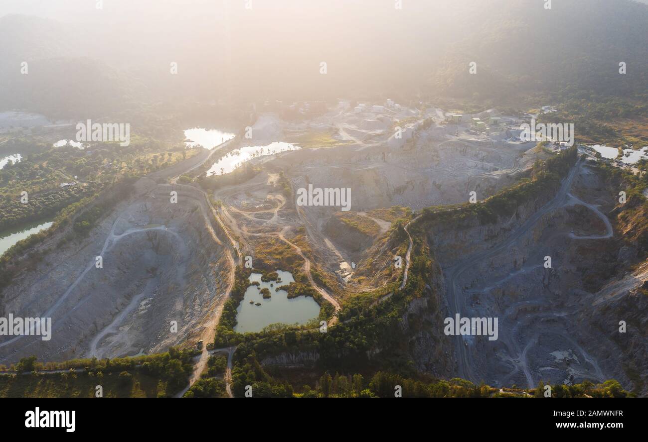 aerial drone Flying over the granite quarry among the forest , cranes ...