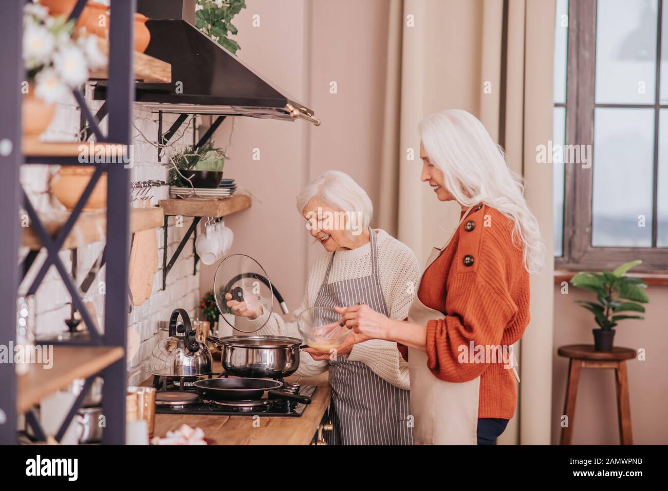 Two elderly women getting the breakfast ready Stock Photo - Alamy
