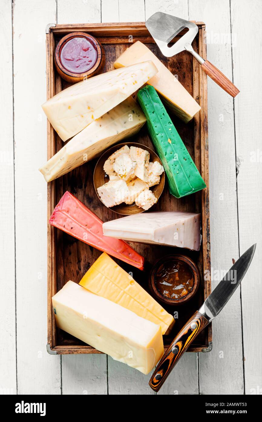 Various kind of cheese served in wooden box.Slices of cheese Stock ...