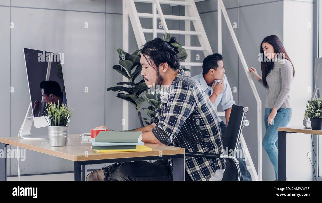 asian creative designer get excited and sitting at desk and staring at ...