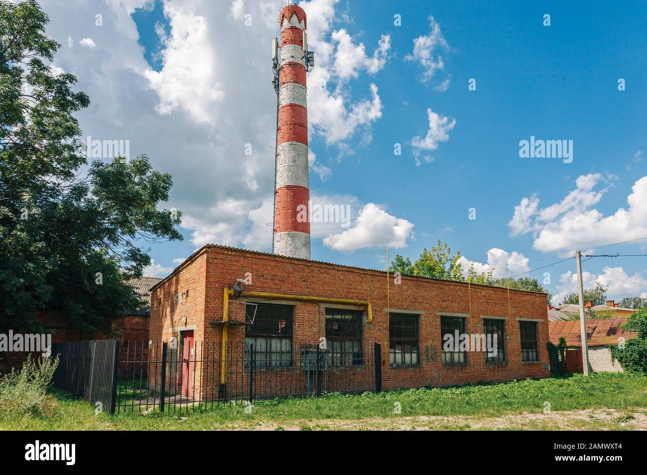 Abandoned factory or plant from red bricks with tall exhaust pipe ...