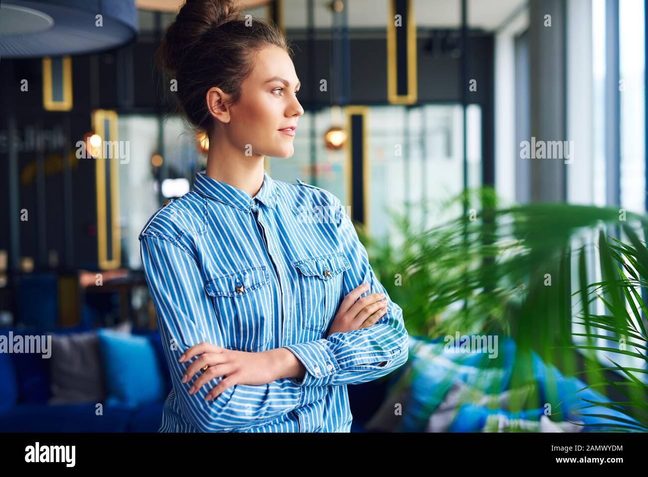 Serious woman looking through window in the office Stock Photo - Alamy