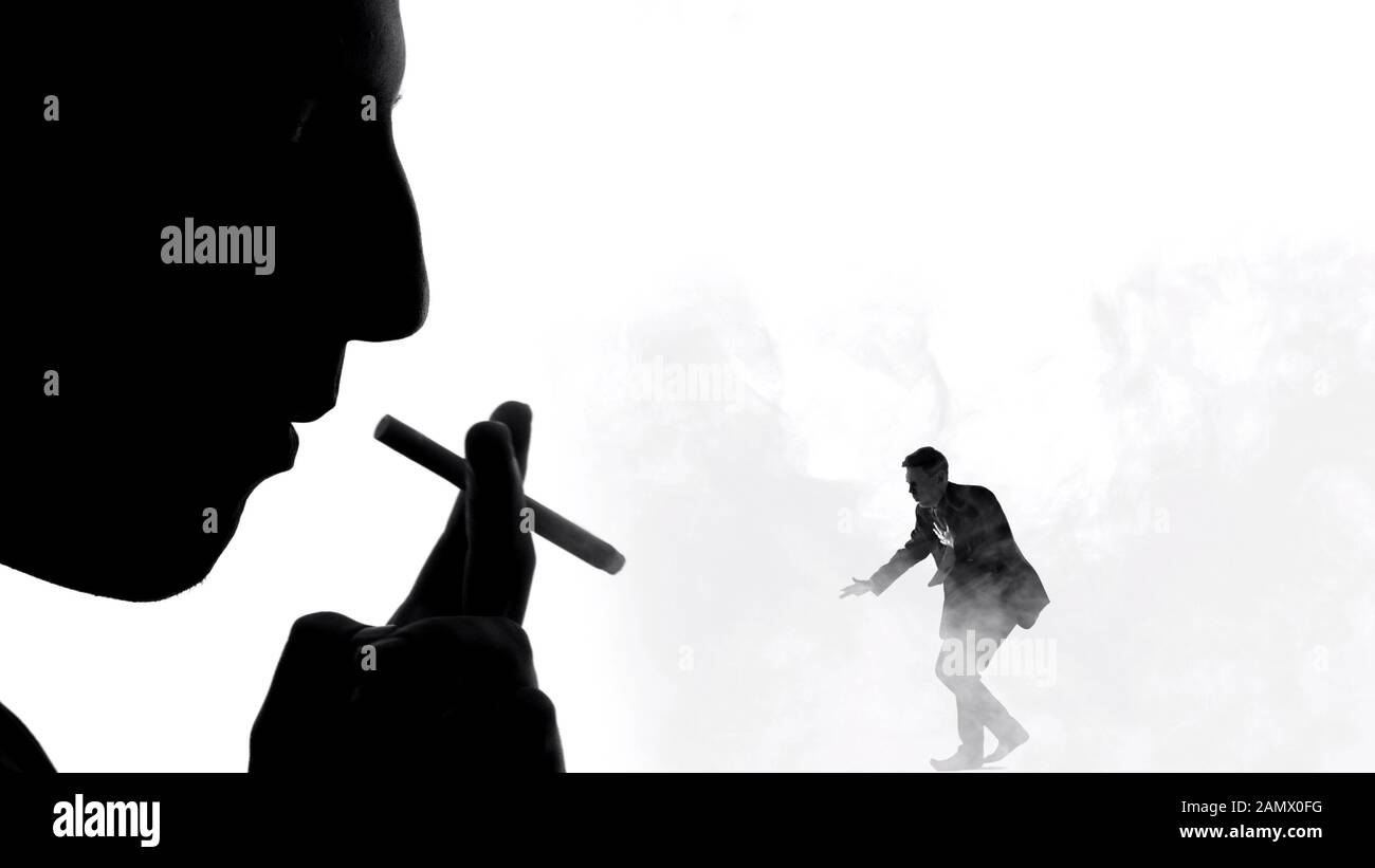 Shadow of male smoking cigarette, exhaling smoke on tiny man, harmful ...