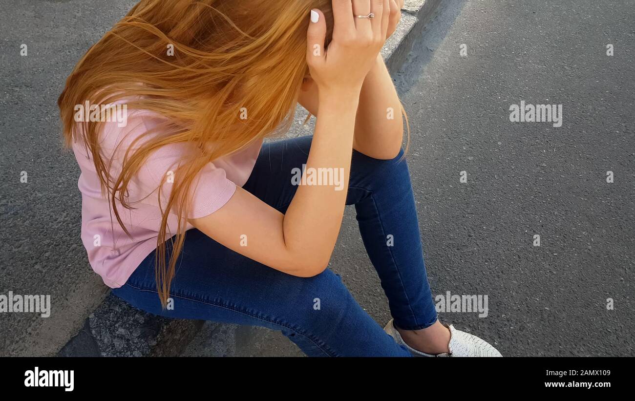 Frustrated girl sitting on sidewalk, victim of pickpocket crying in ...