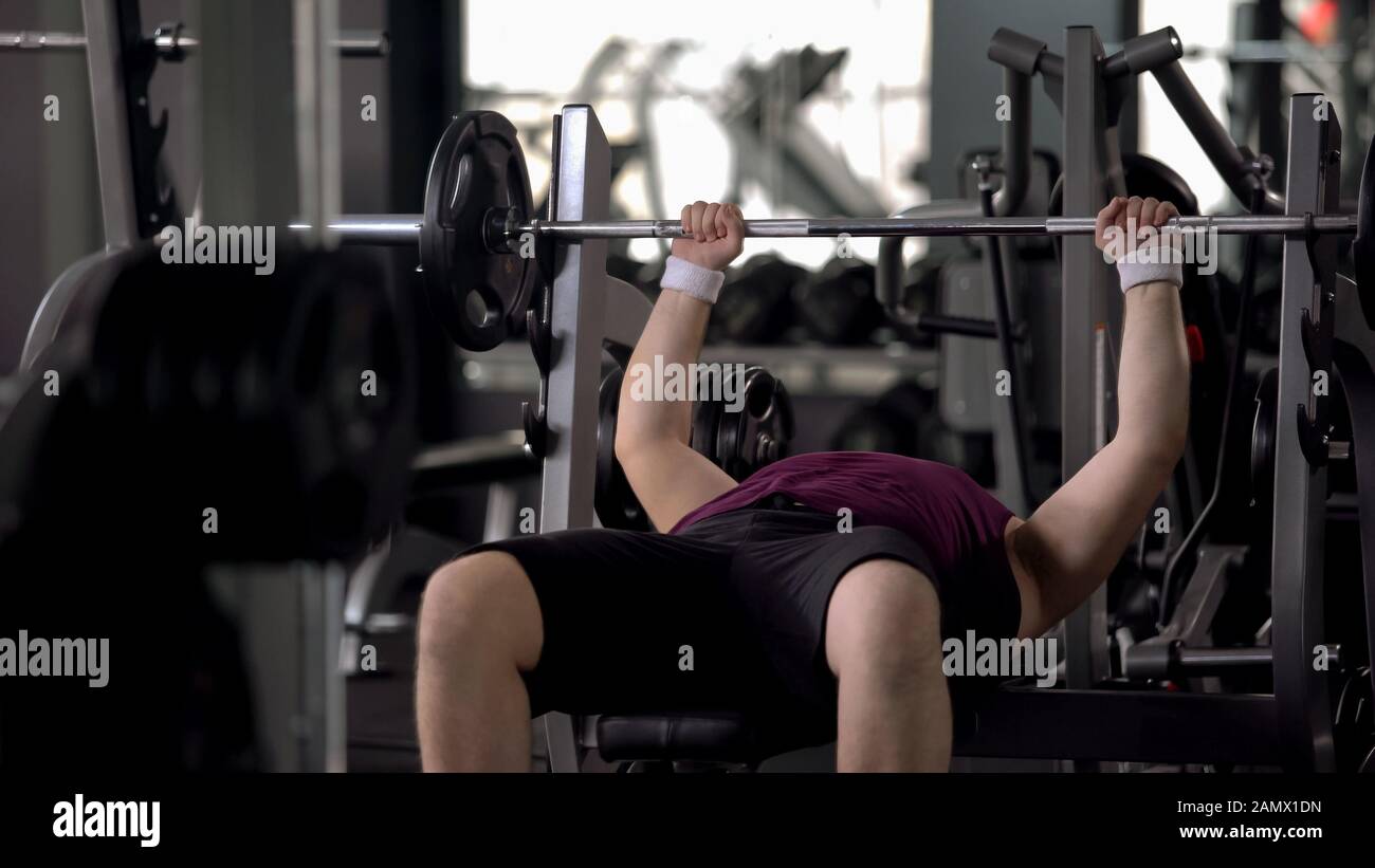 Fat man lifting up barbell, personal workout plan, desire to be strong ...