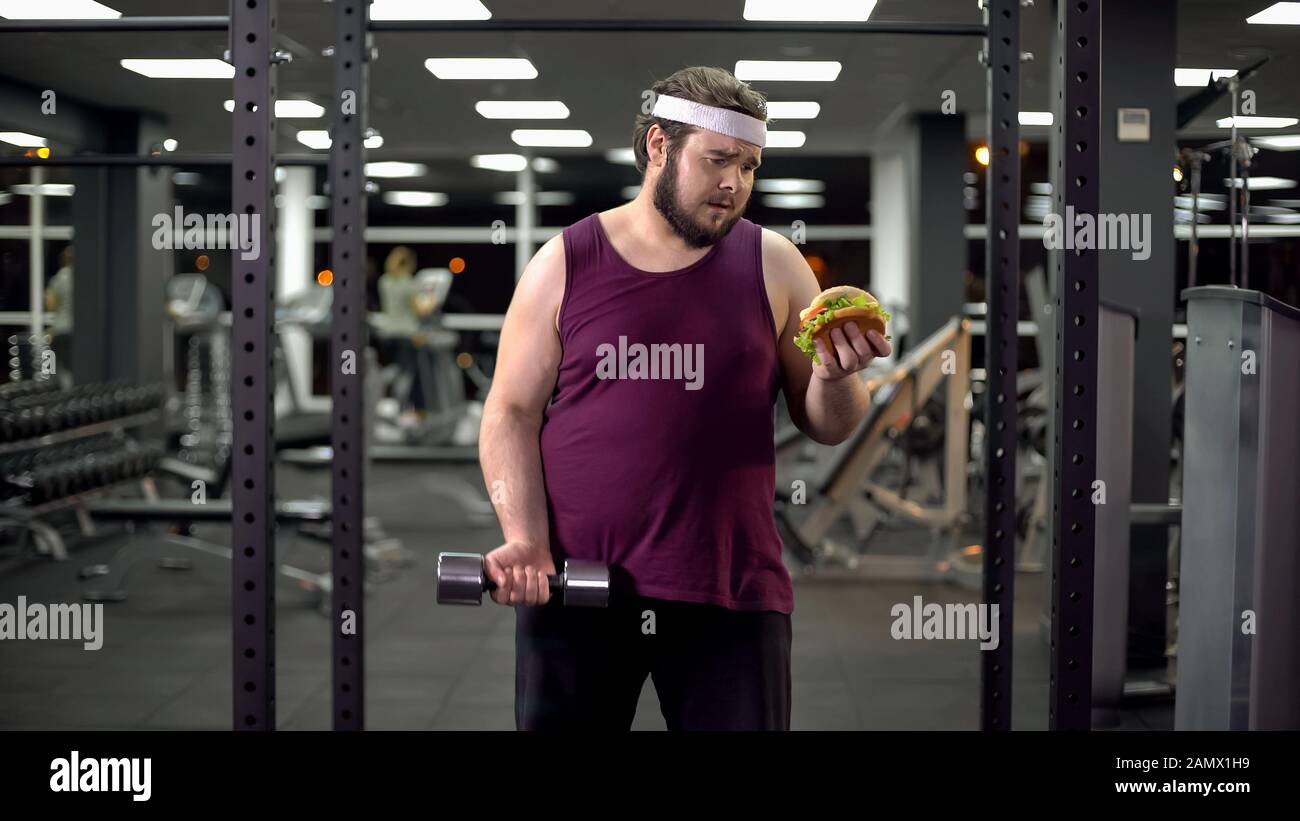 Overweight Man Holding Burger And Dumbbell In Hands Life Decision