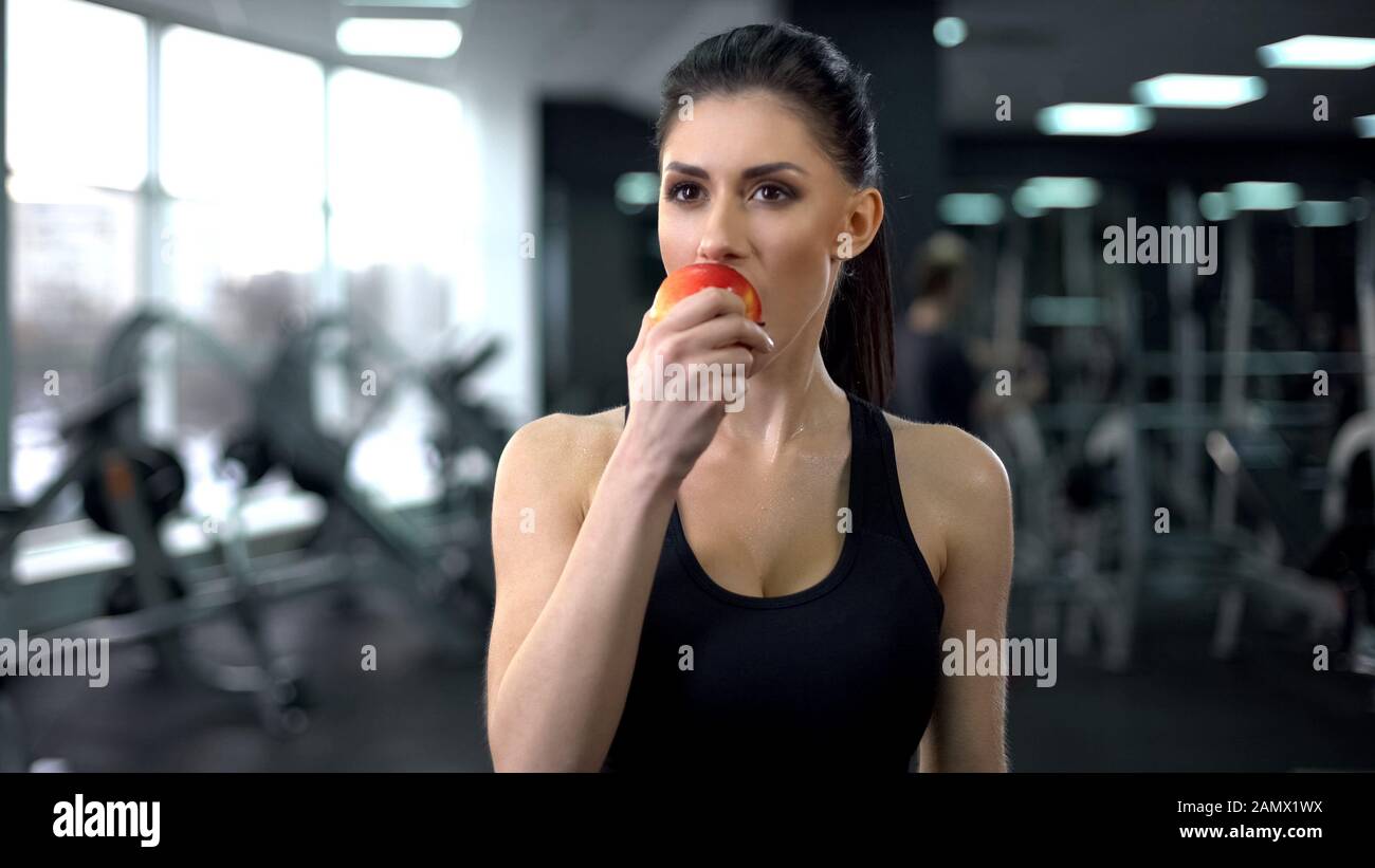 Sport female eating apple after workout, balanced nutrition, active ...