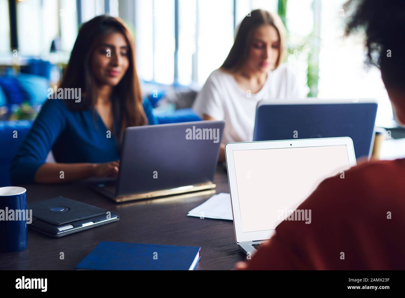 Blurred view of coworkers working at office desk Stock Photo - Alamy
