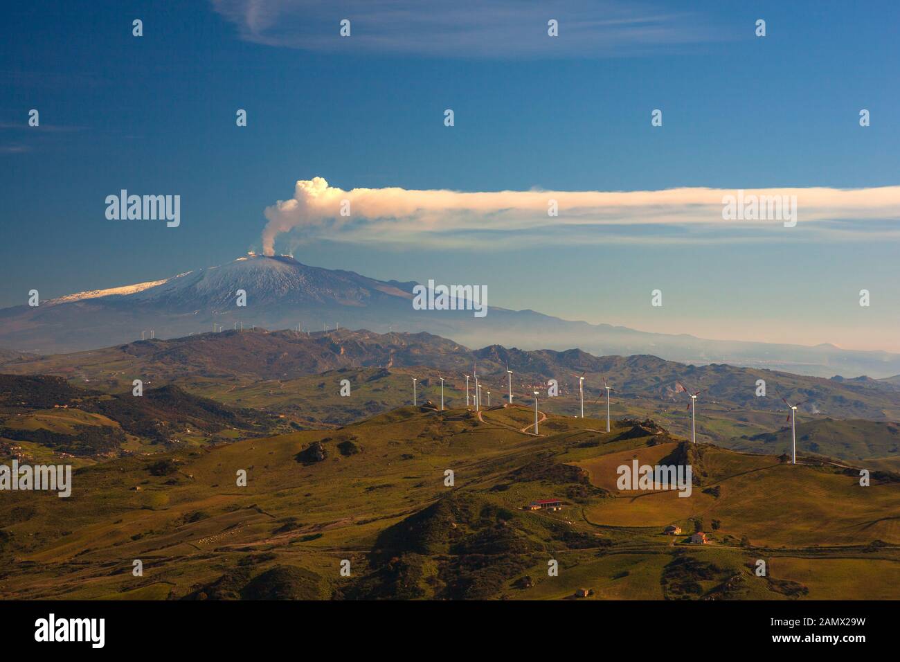 View of windmills and the mount Etna Volcano with smoke. Sicily Stock ...
