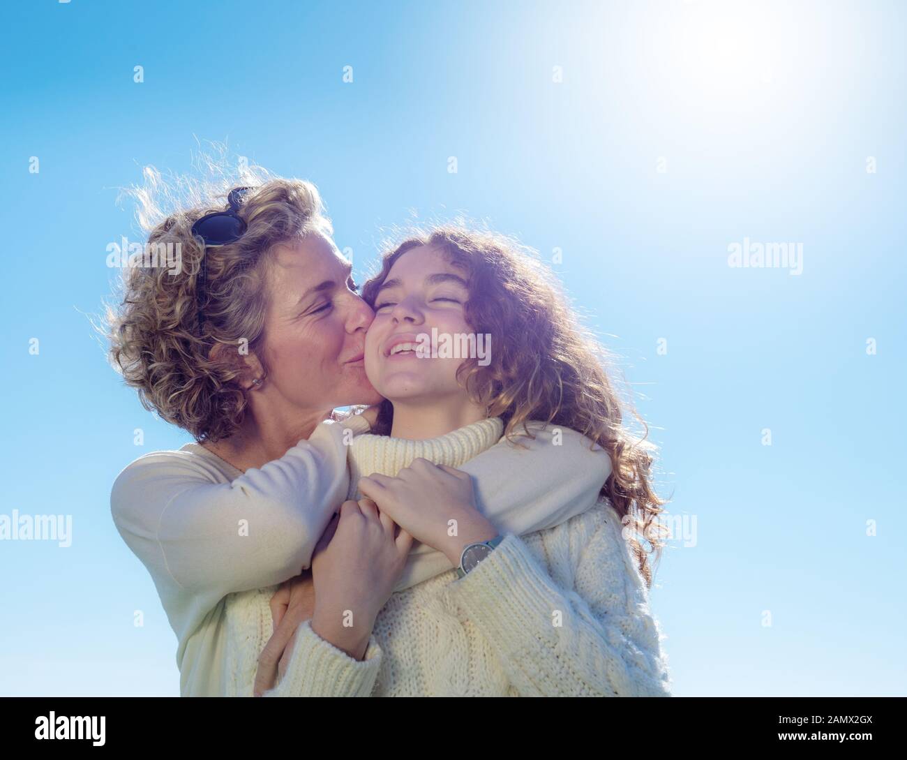 Young woman with her daughter in a very loving attitude. Burnt sky copy ...
