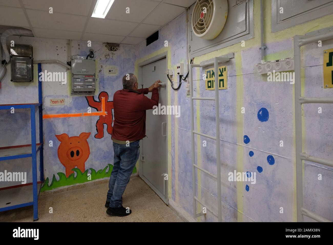 An Israeli civilian opens a heavy metal door inside a public bomb ...