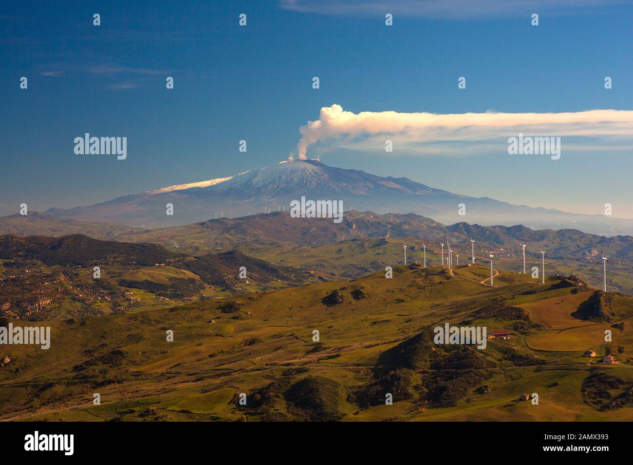 View of windmills and the mount Etna Volcano with smoke. Sicily Stock ...