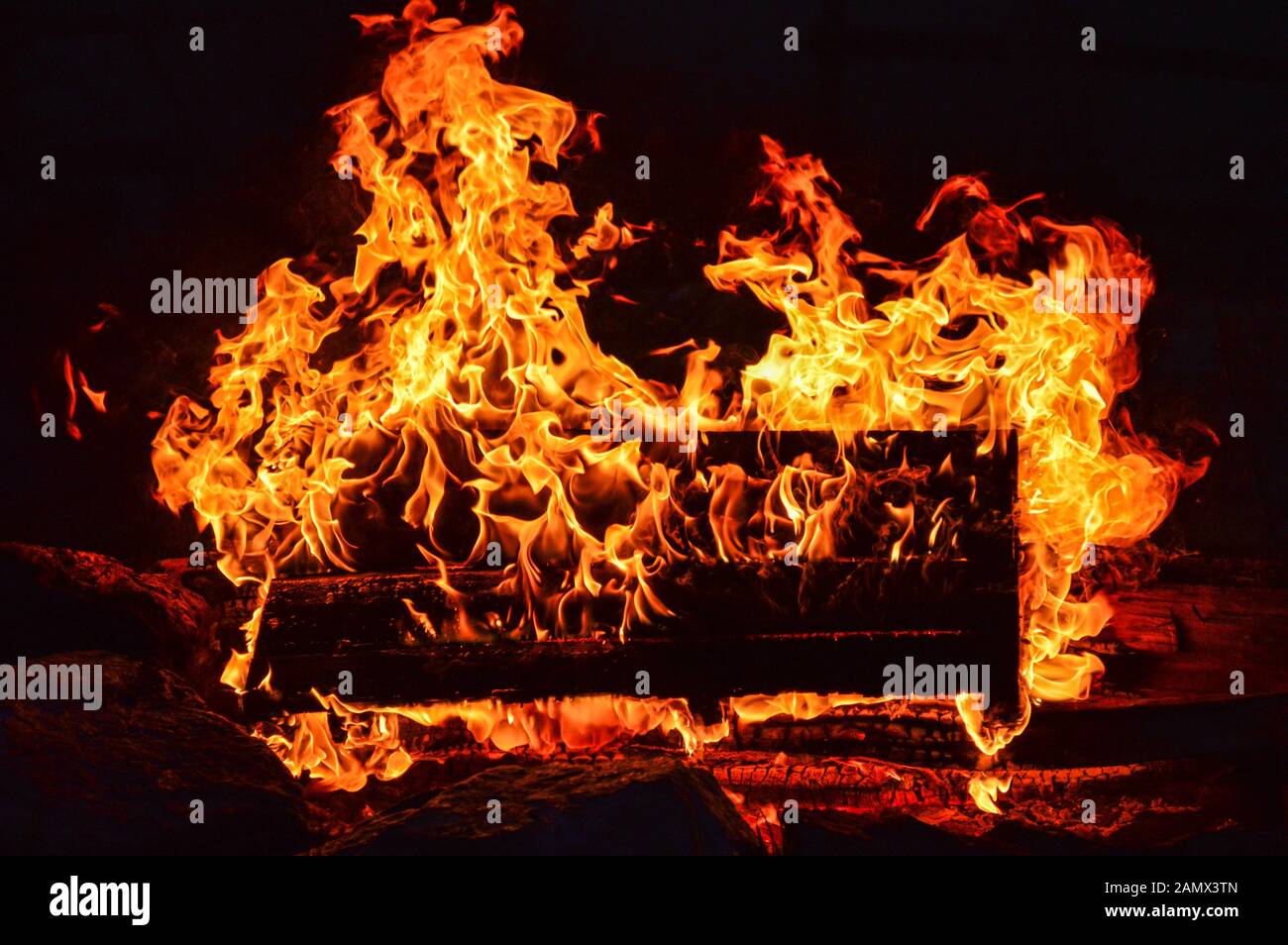 A wooden pallet burns on an outdoor fire in the late evening Stock ...