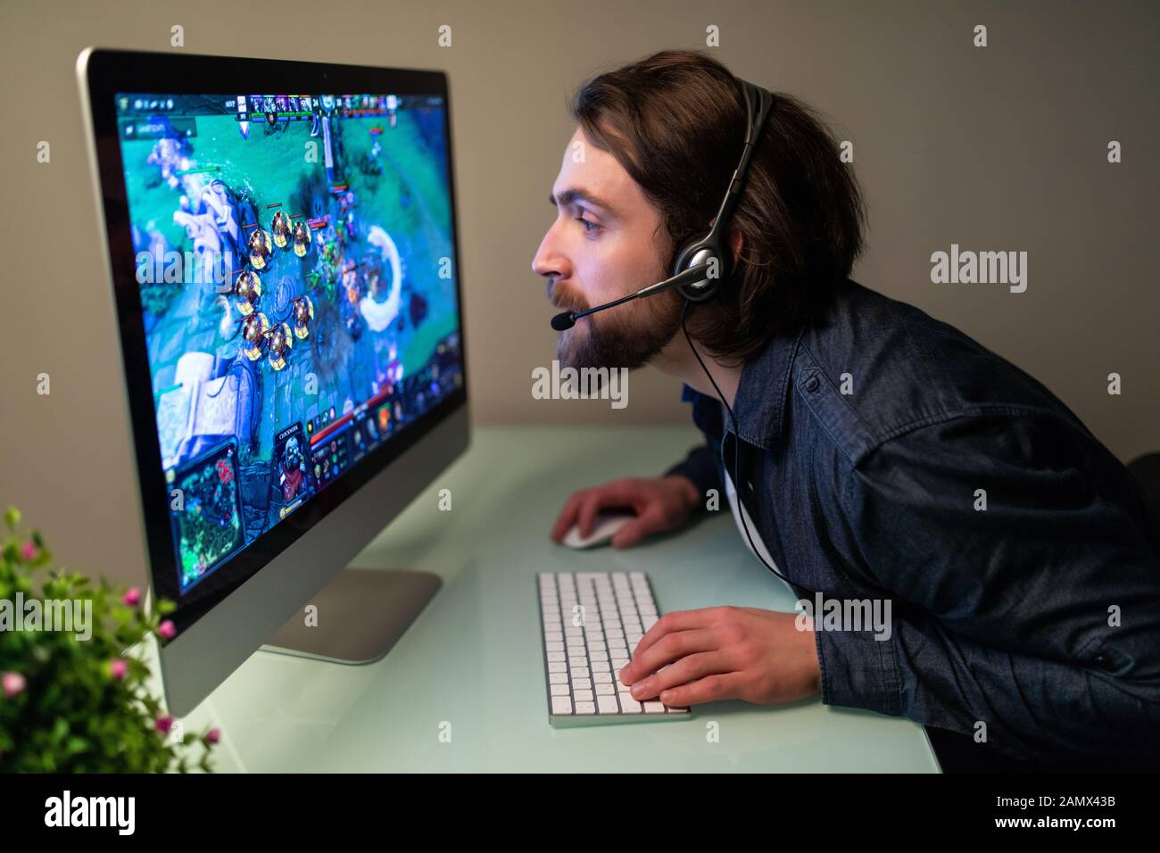 Image of cheerful gamer man playing video games on computer wearing ...
