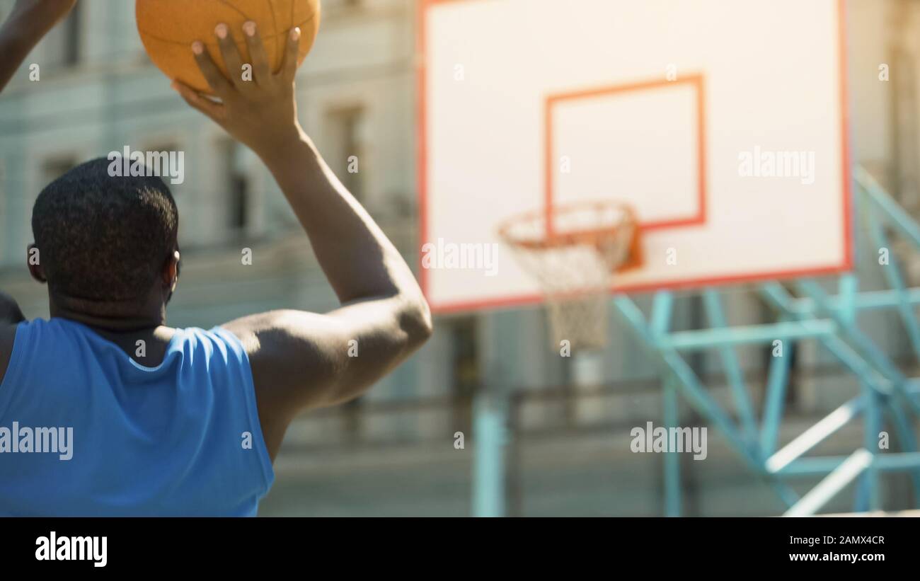 Black male in sportswear throwing ball into basket, active lifestyle ...