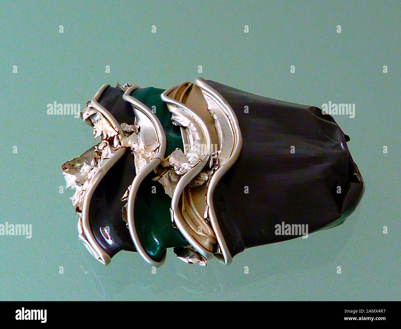 flattened spent aluminum coffee capsules on grainy glass surface ...