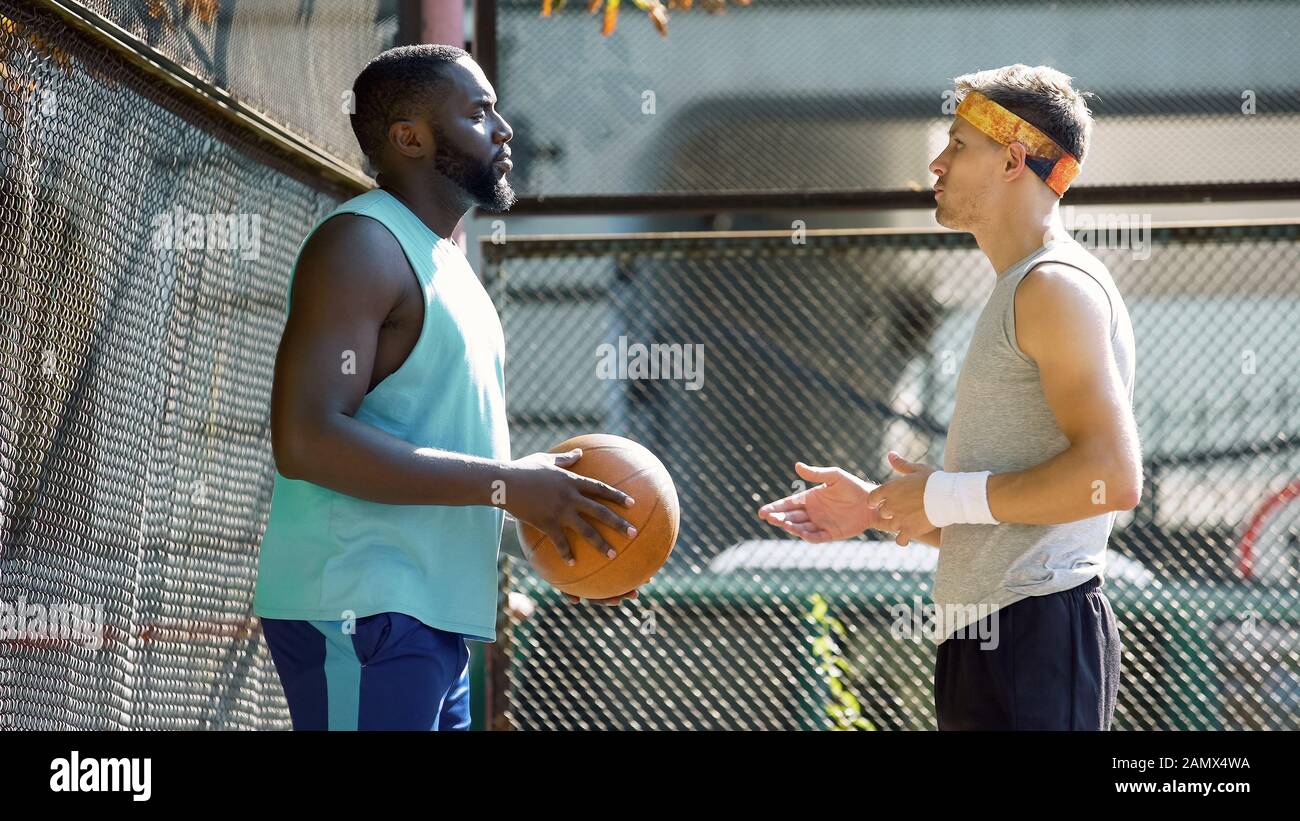 Trainer and basketball player talking about future game, active ...