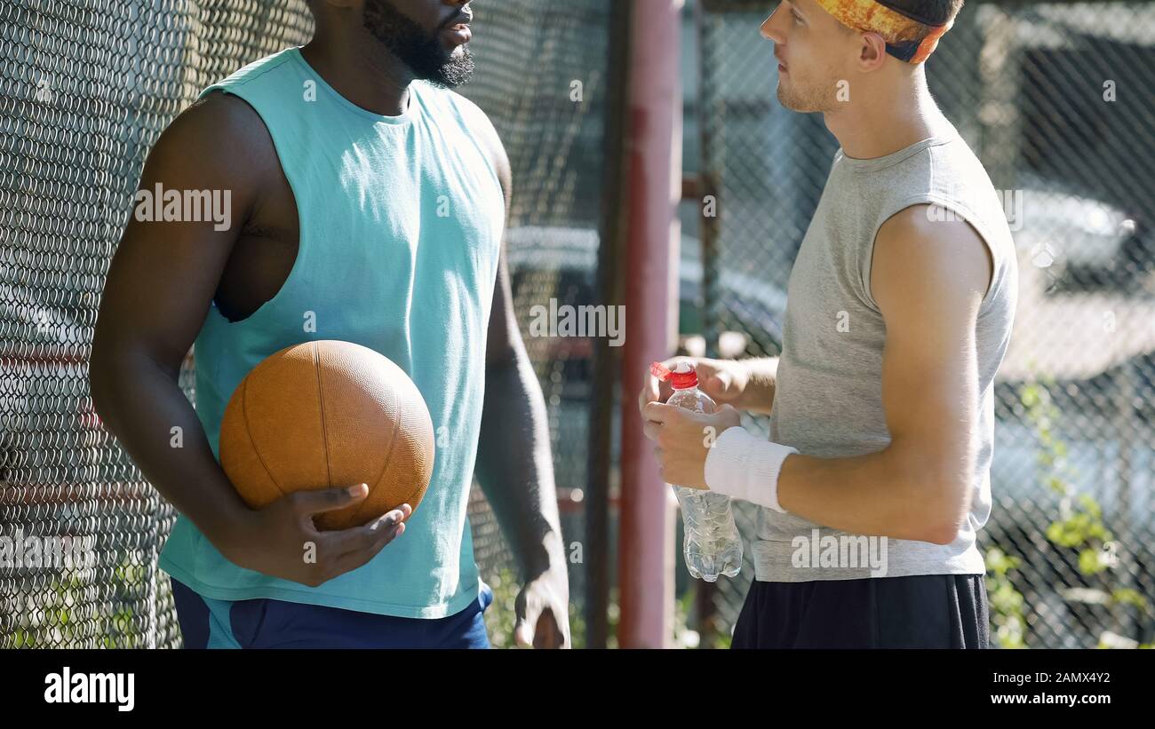 Muscular basketball player talking about last game score at stadium ...