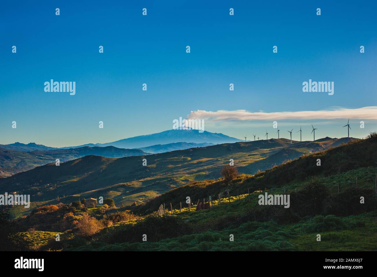 View of windmills and the mount Etna Volcano with smoke. Sicily Stock ...
