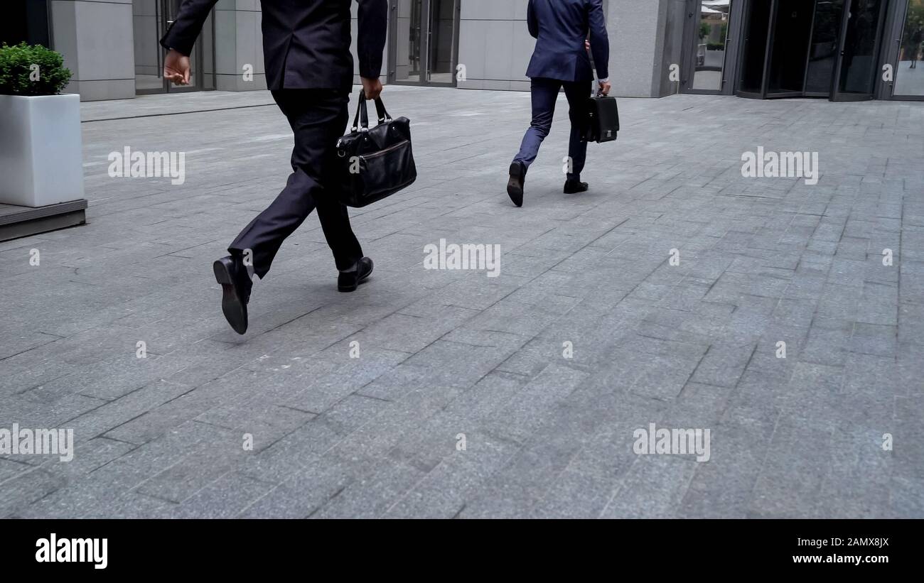 Employees hurrying to important meeting in business center, time ...