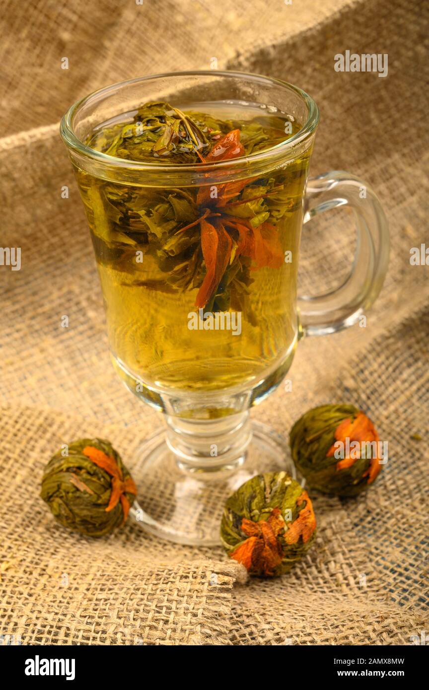 Flower tea brewed in a glass Cup and balls of flower tea on a ...
