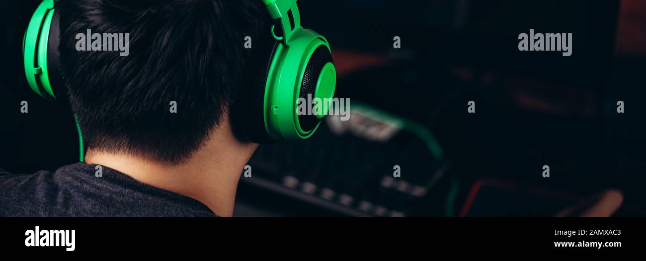 Back view of gamer in headphones playing video game Stock Photo - Alamy