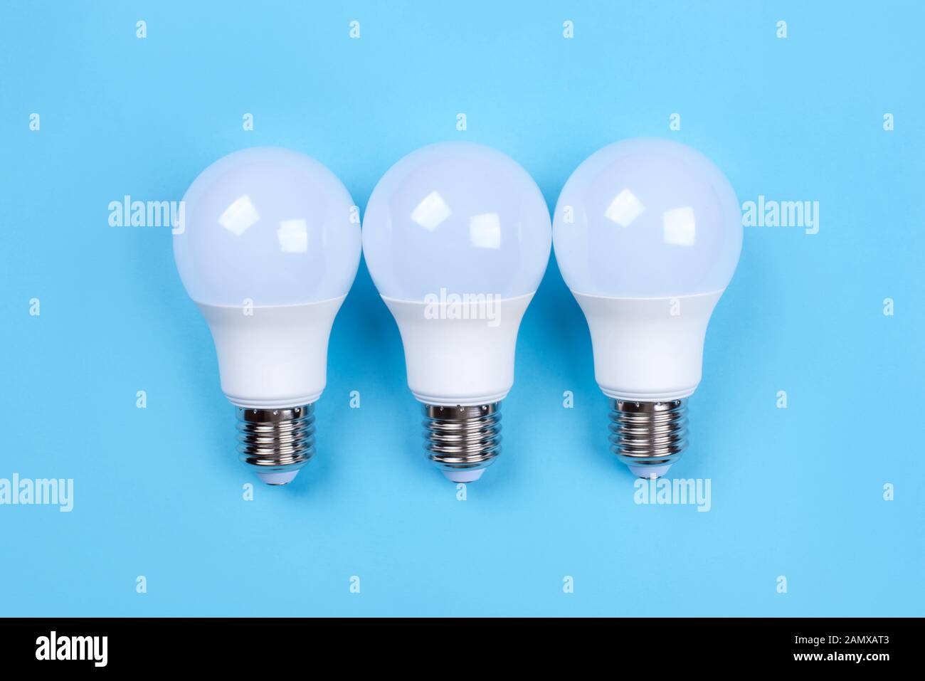 Three LED bulbs on blue background. Saving energy concept Stock Photo ...