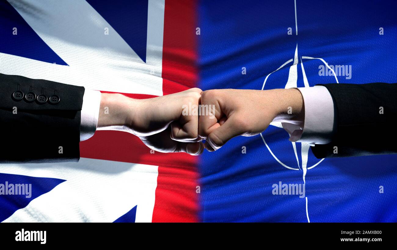 Great Britain vs NATO conflict, fists on flag background, diplomatic ...