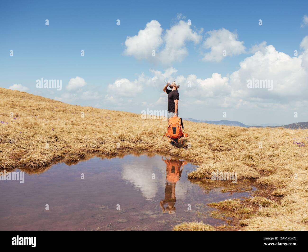 Hiker drinking water from bottle, hiking hydration Stock Photo - Alamy