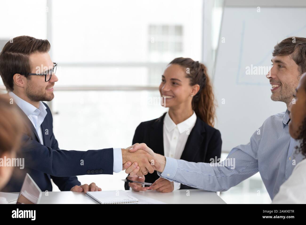 Smiling male business partners handshake at office meeting Stock Photo ...