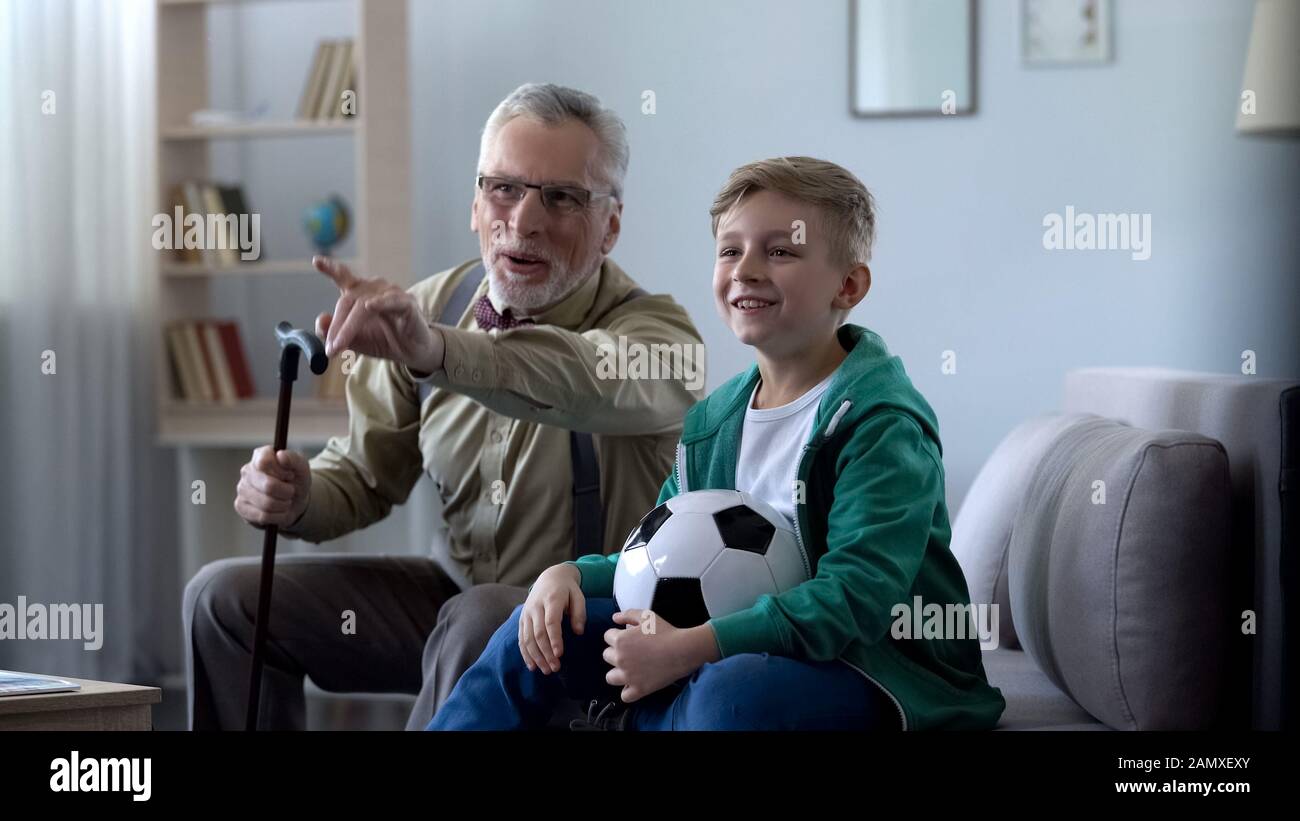 Granddad and grandson cheering for favorite football team, happy for ...