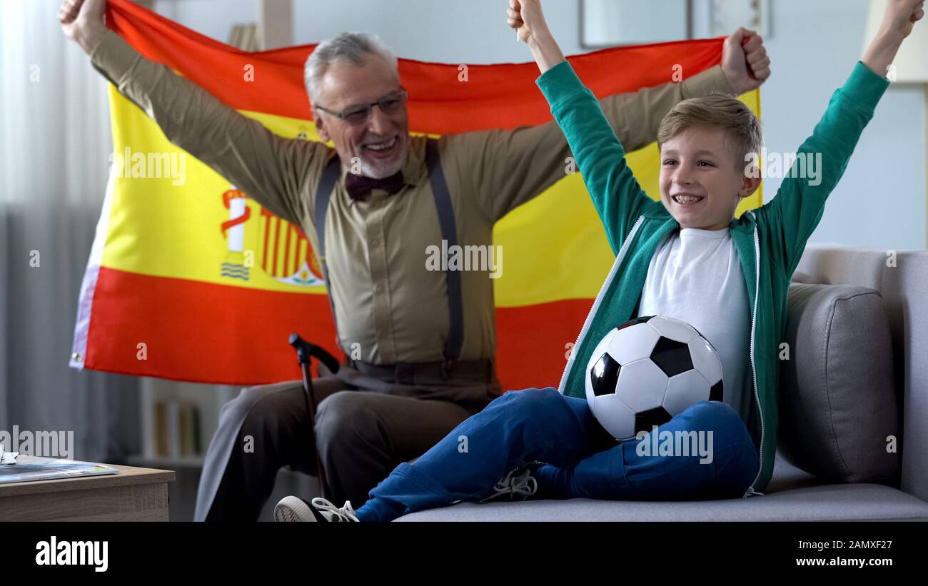 Grandpa waving Spanish flag, together with boy rejoices victory of ...