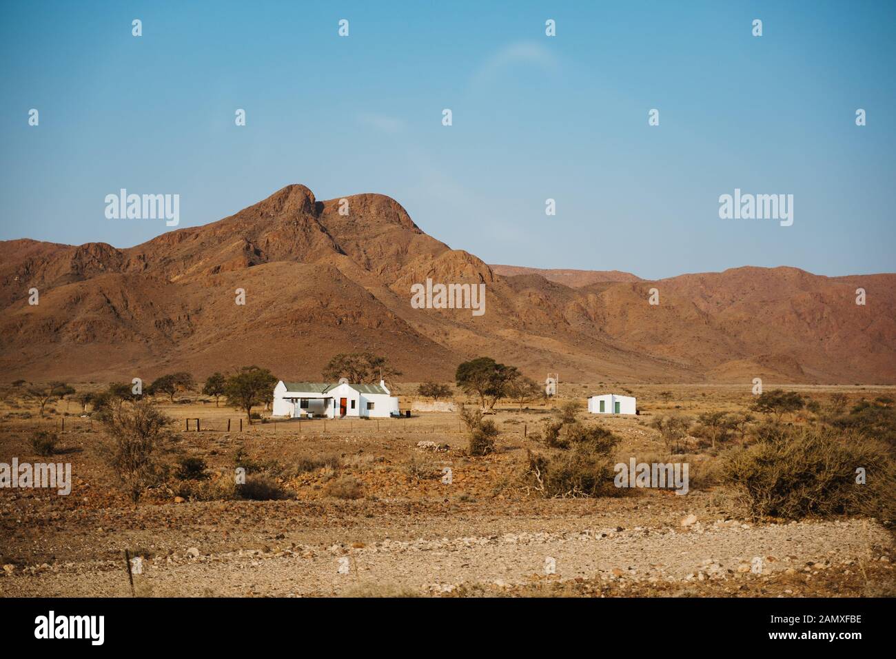 lonely farmers house in the desert of Namibia with mountains in ...