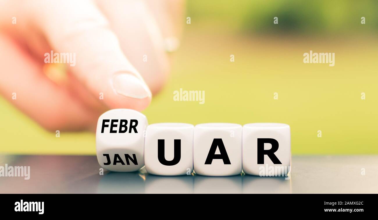 Hand turns a dice and changes the German word "Januar" ("January" in ...